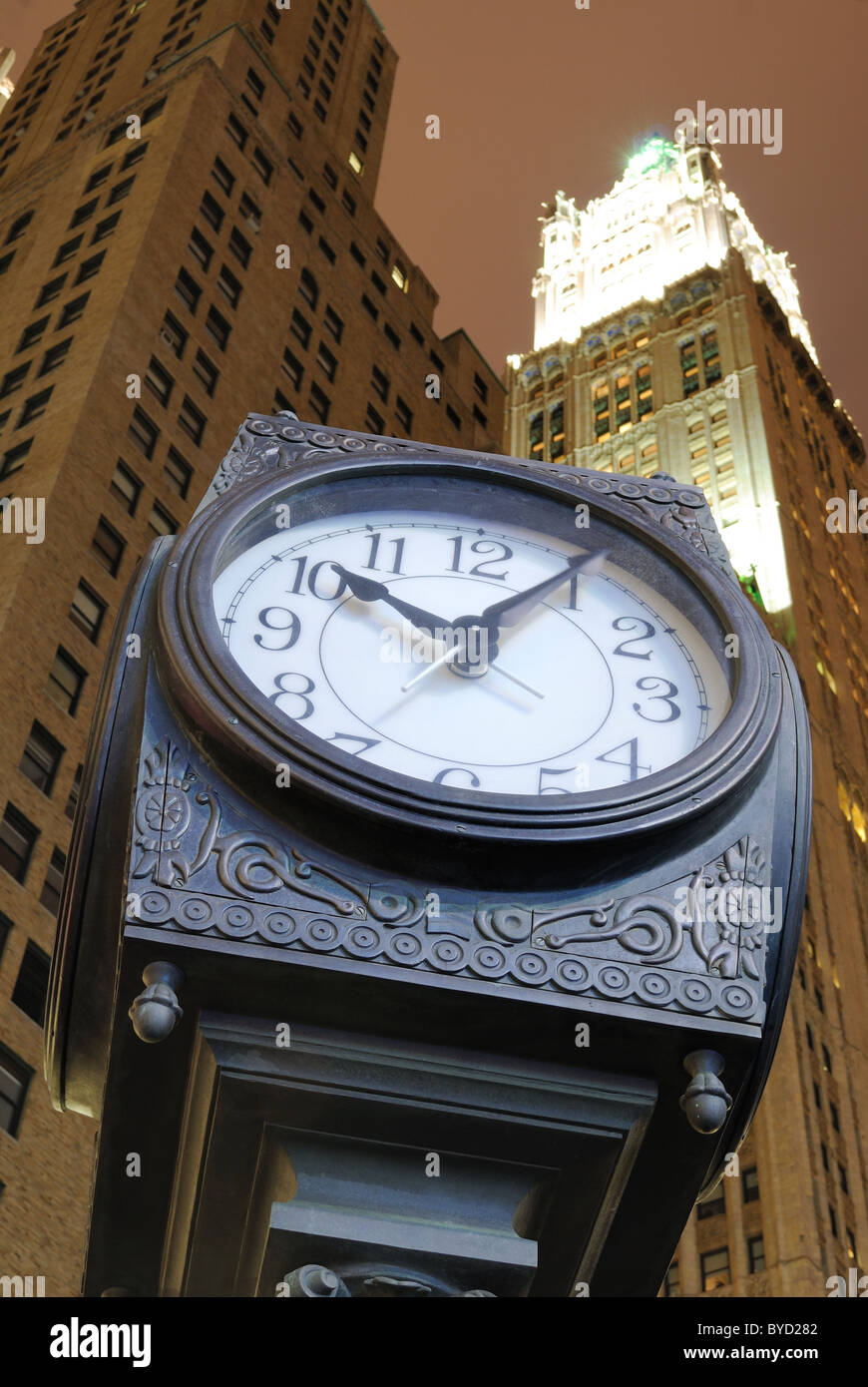 An old fashion clock in downtown Manhattan with skysrcrapers behind it ...