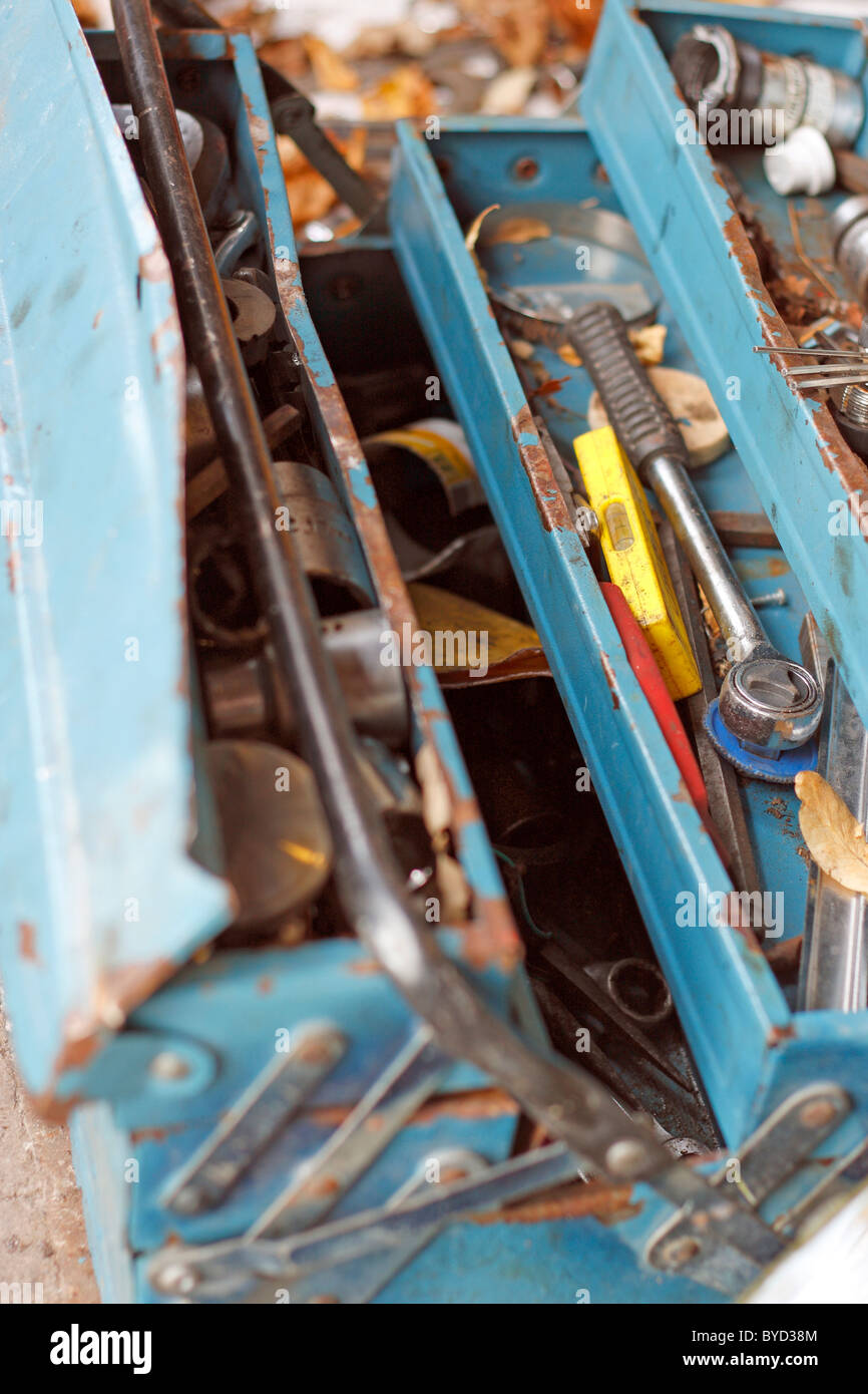 An old blue rusty metal tool box lying on the floor of a garage Stock ...
