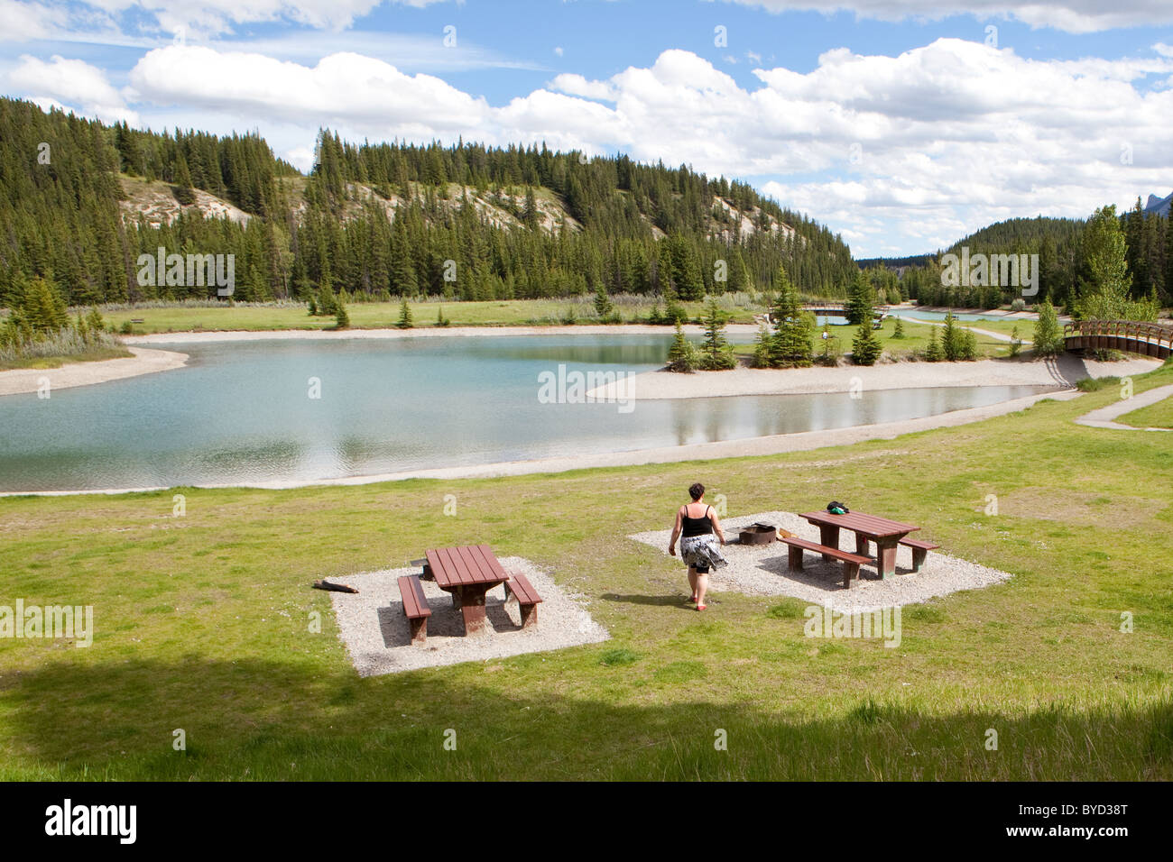 A woman walks between two picnic tables at the Cascade Ponds outside ...