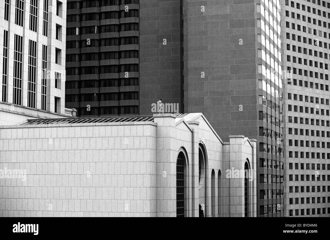 The solitary figure of a man stands on the roof of an office building ...