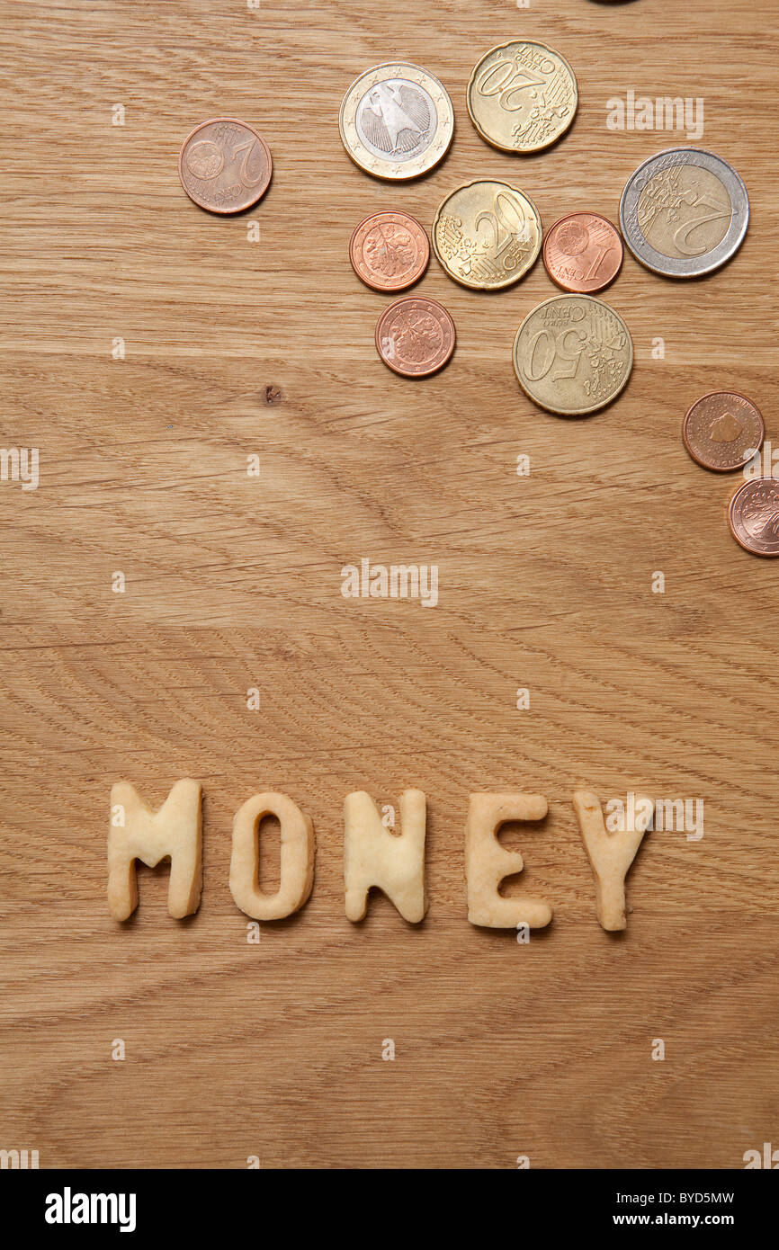 Money, word written with biscuits, beside coins Stock Photo - Alamy