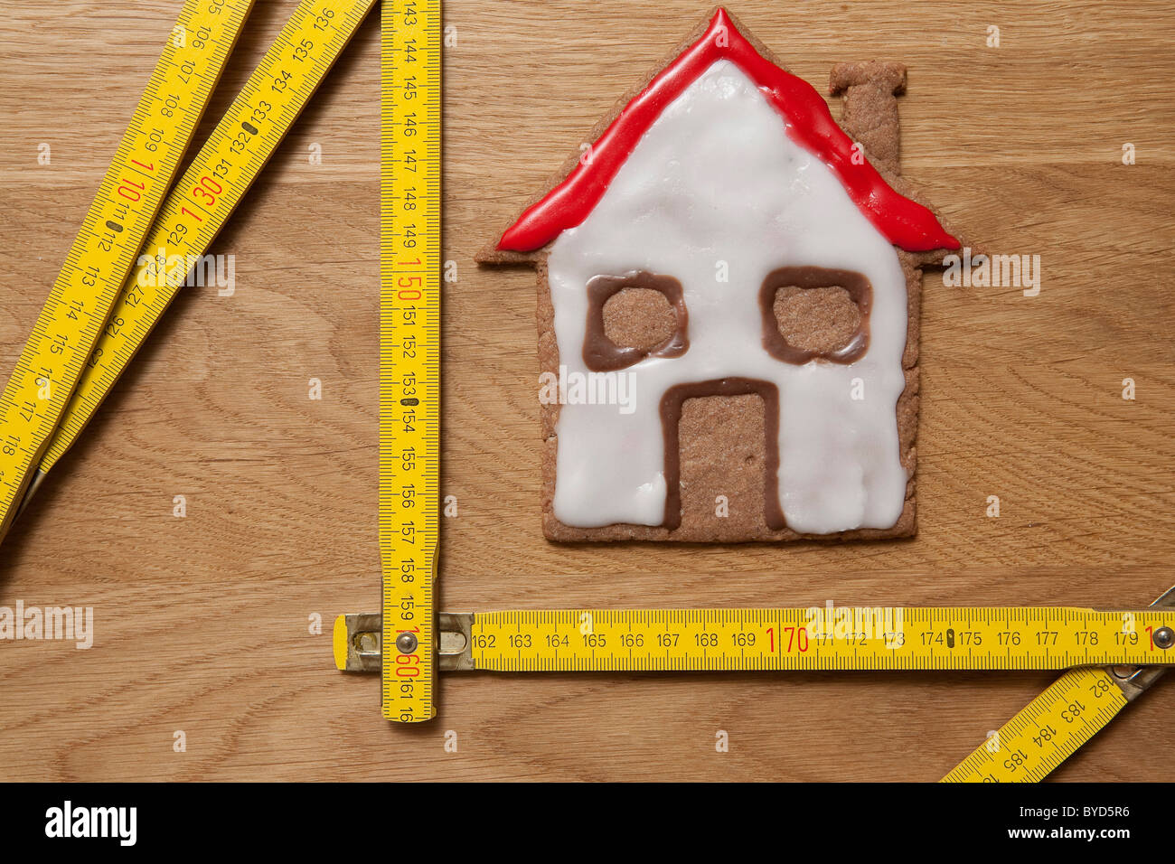 House biscuit with a measuring stick, symbolic image for home ...