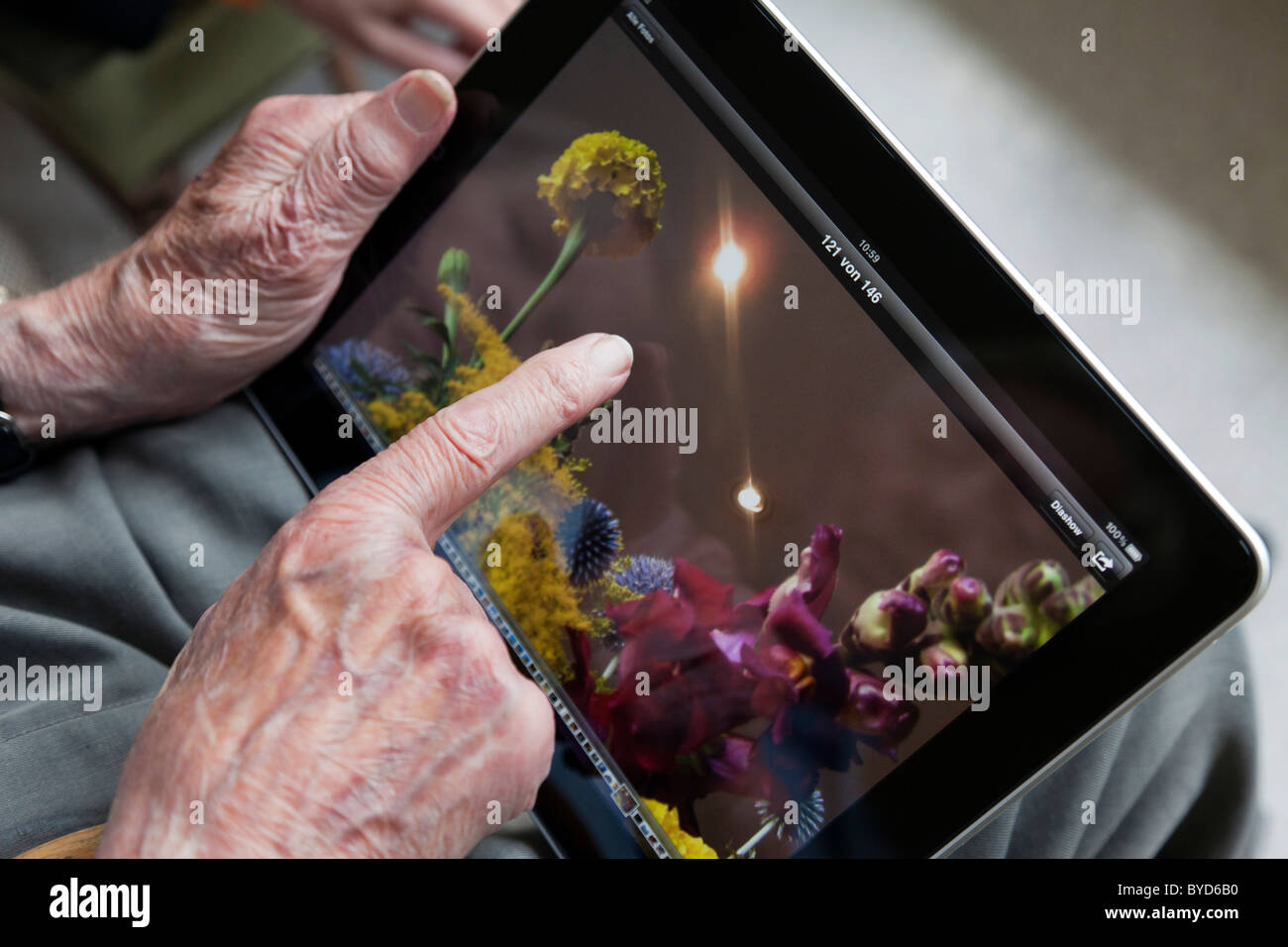 Senior viewing photos on an iPad, close-up of his hands Stock Photo - Alamy