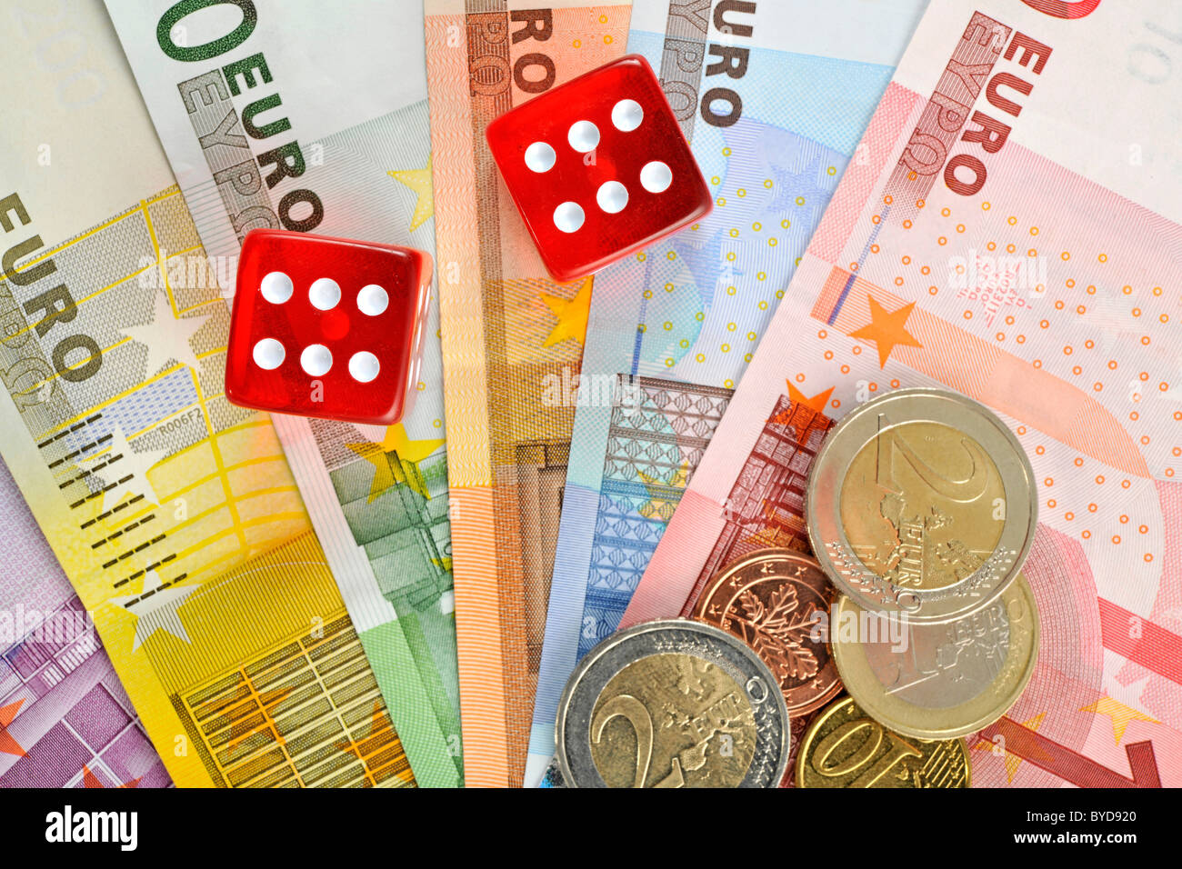 Coins and dice on a fan of various euro banknotes, symbolic image for ...