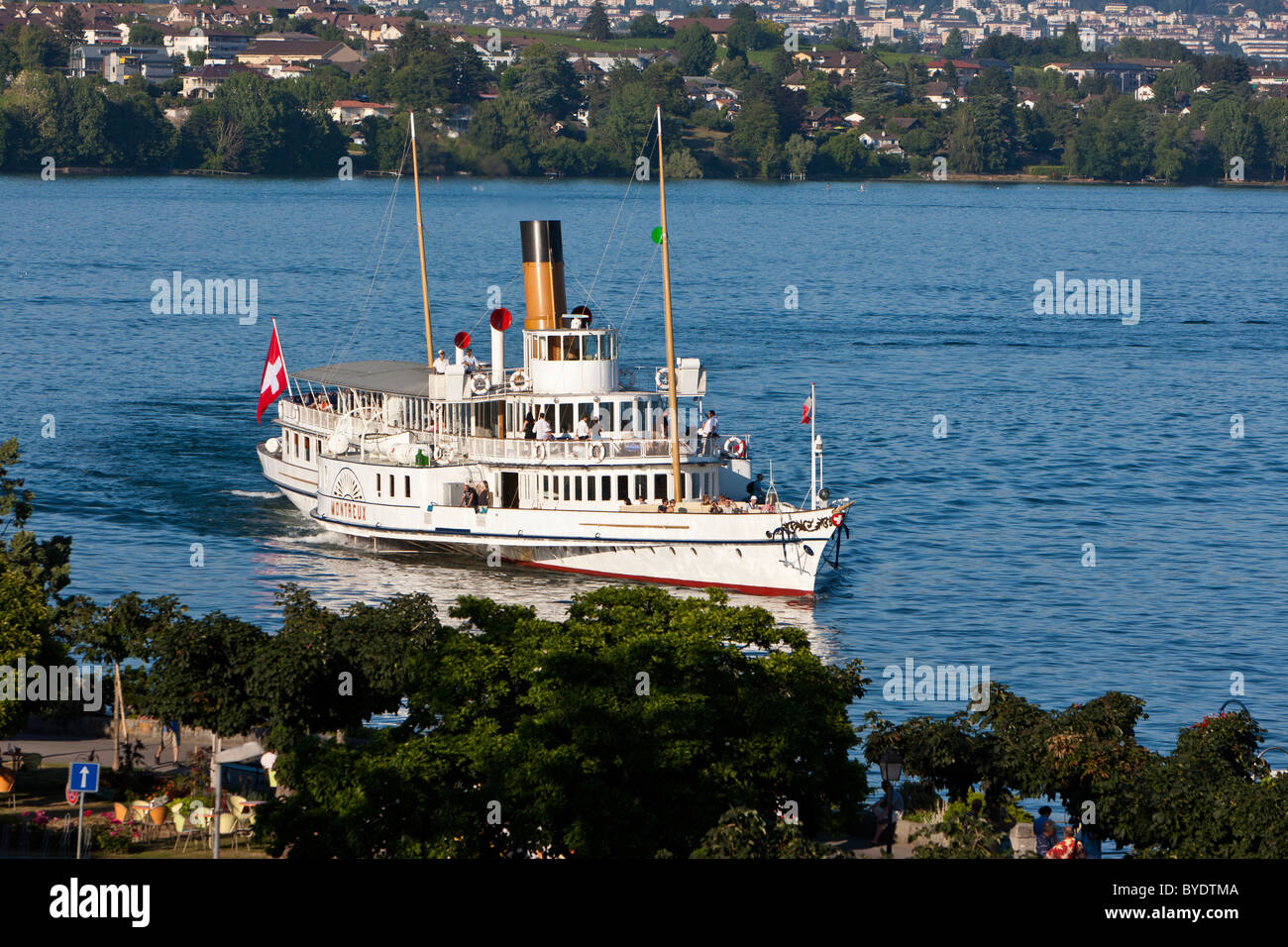 An old paddle-steamer as a ferry for tourists approaching a dock near ...
