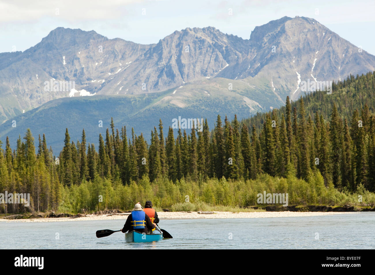 Two men in a canoe, canoeists paddling, canoeing upper Liard River ...