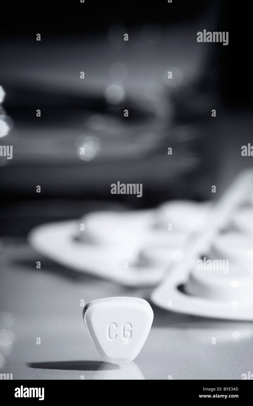 Tablets in front of a glass of water Stock Photo - Alamy