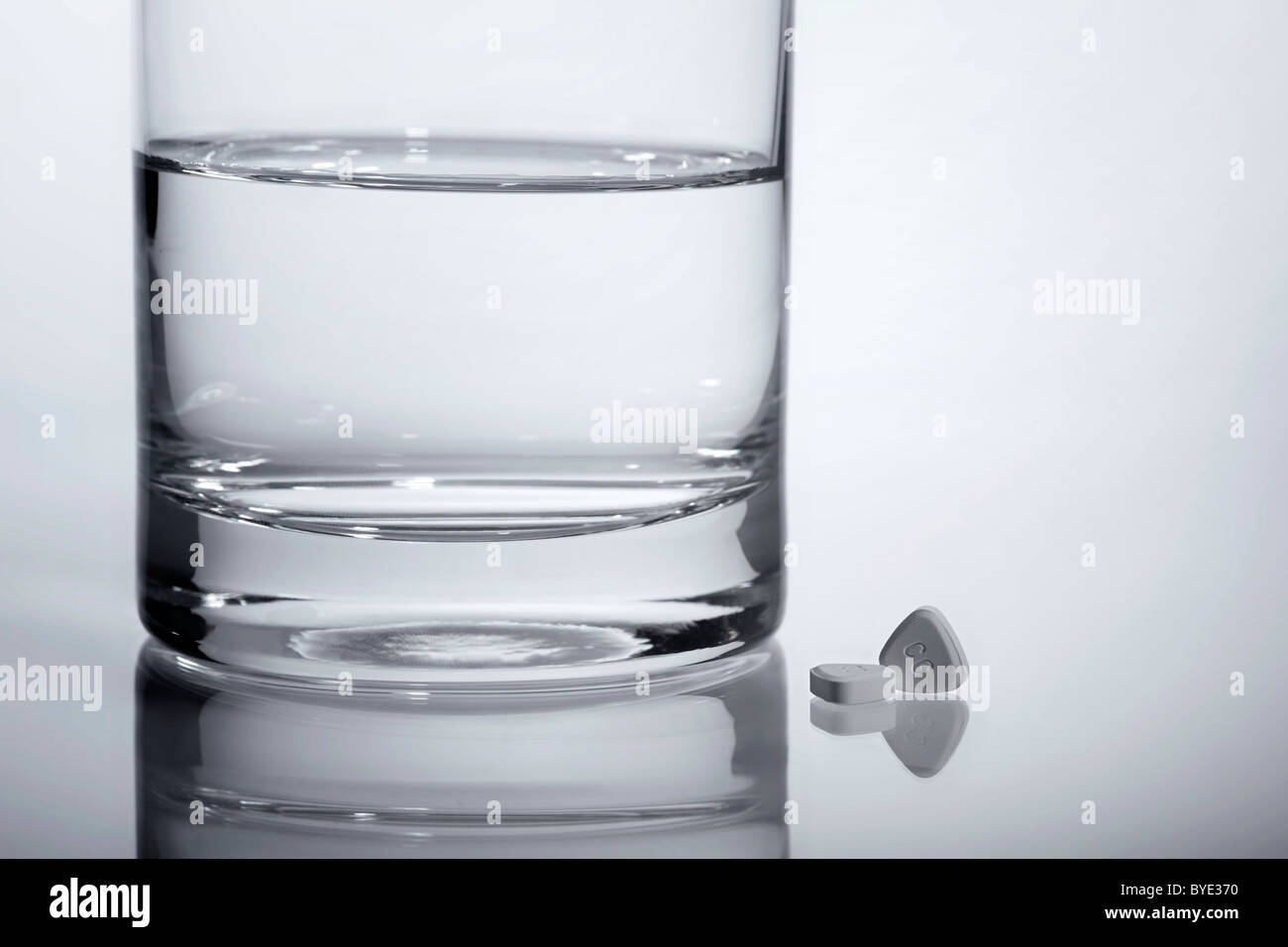Tablets next to a water glass Stock Photo - Alamy