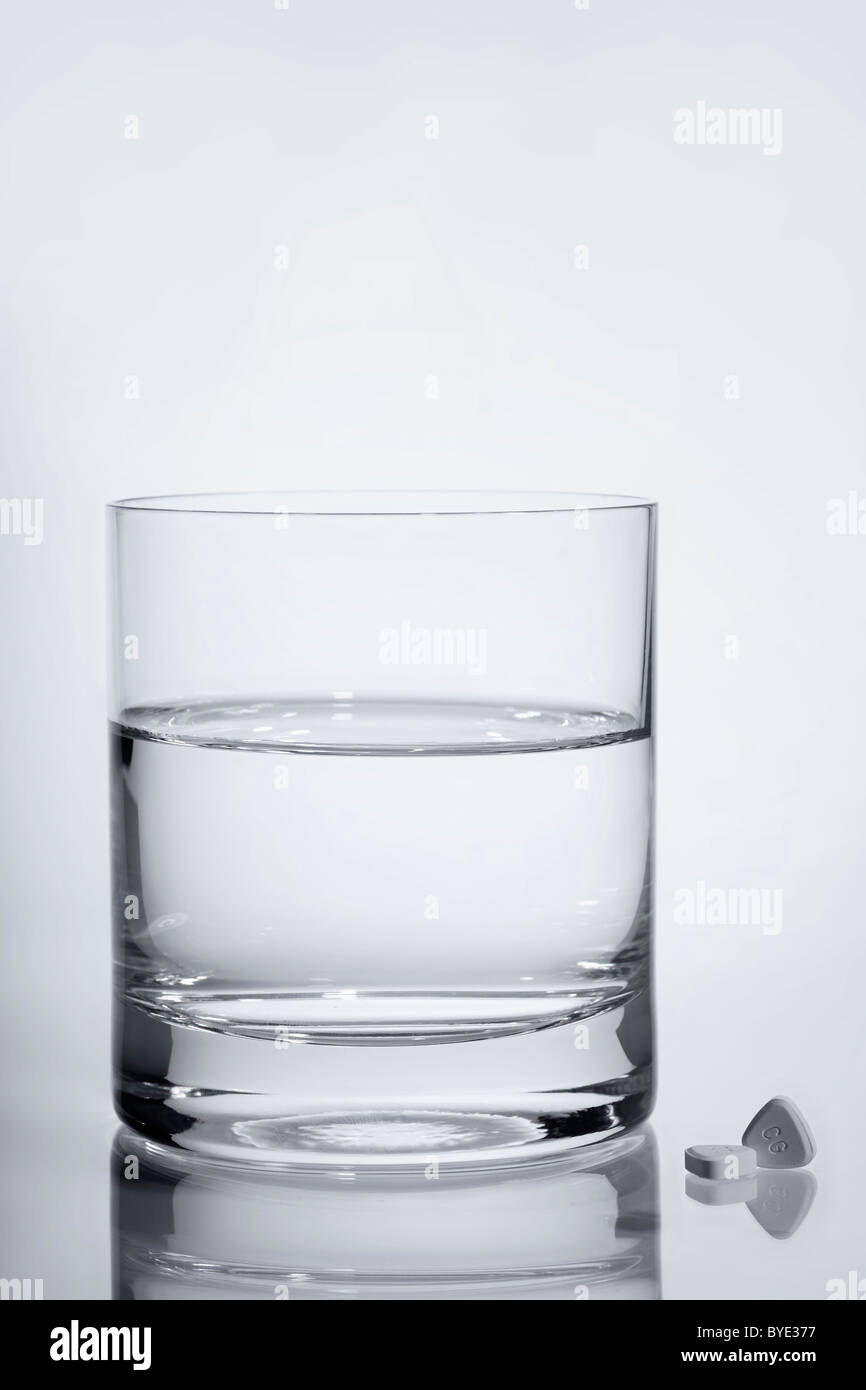 Tablets next to a water glass Stock Photo - Alamy