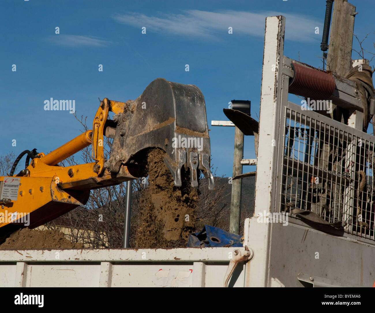 Sand falling from the bucket of a JCB Digger, into an awaiting lorry ...