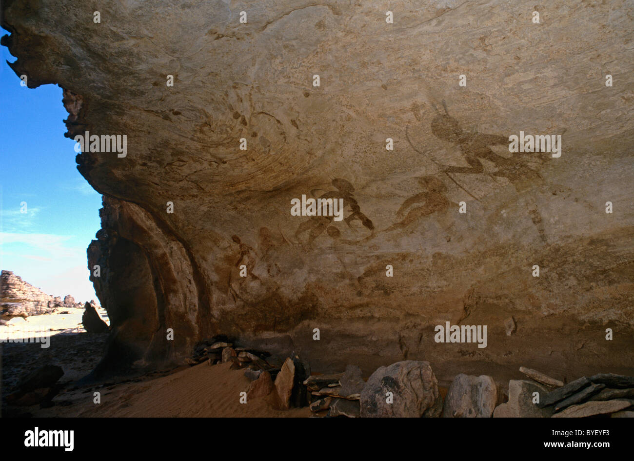 Hunter with Bow & arrows with floating figures on Sahara rock face in ...