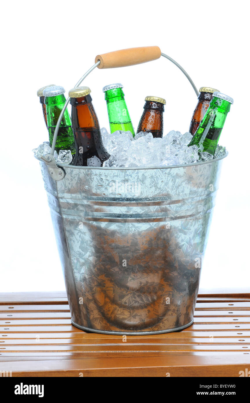 Beer Bucket filled with assorted bottles and ice cubes on teak table in ...