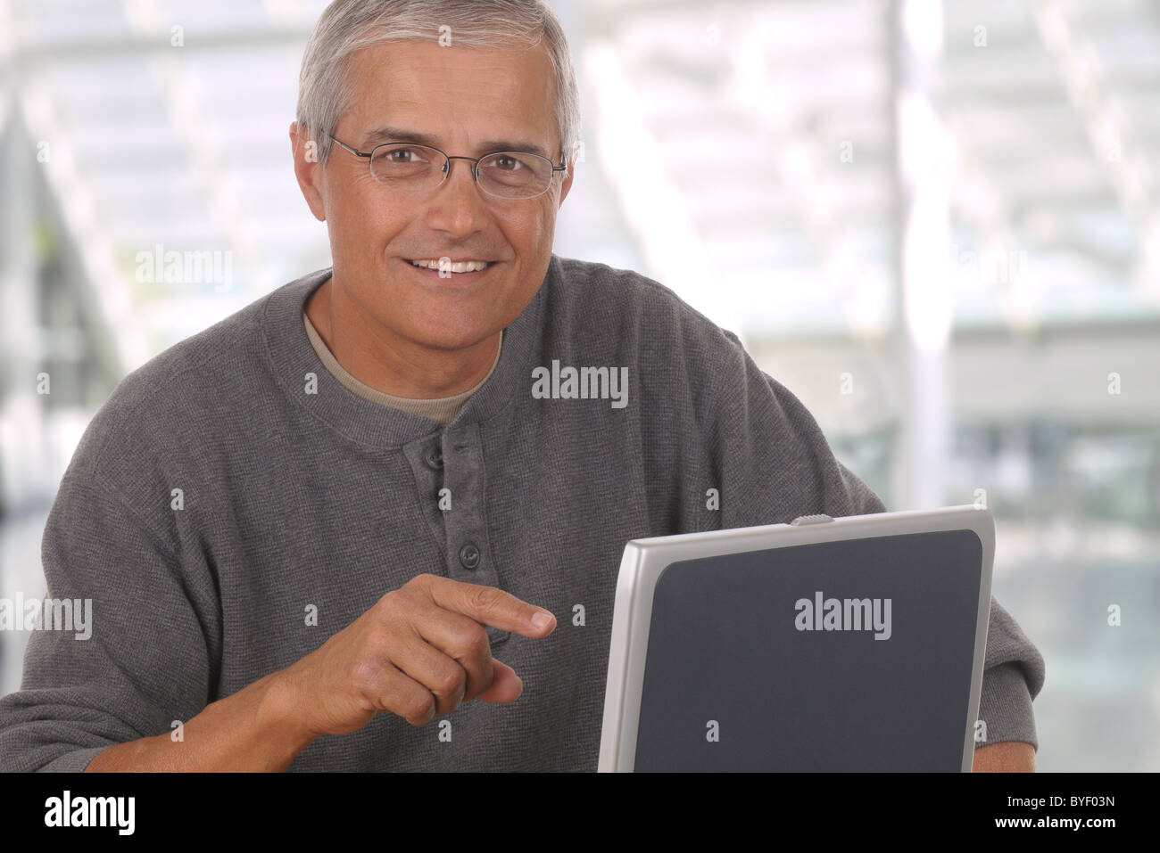 Middle aged man in lobby of modern office building laptop computer. Man ...