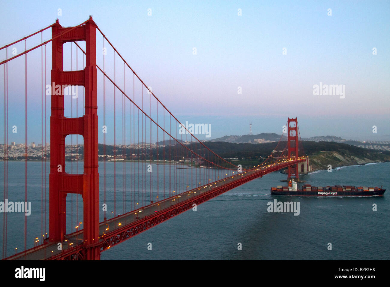 Container ship and the Golden Gate Bridge at dusk in the San Francisco ...