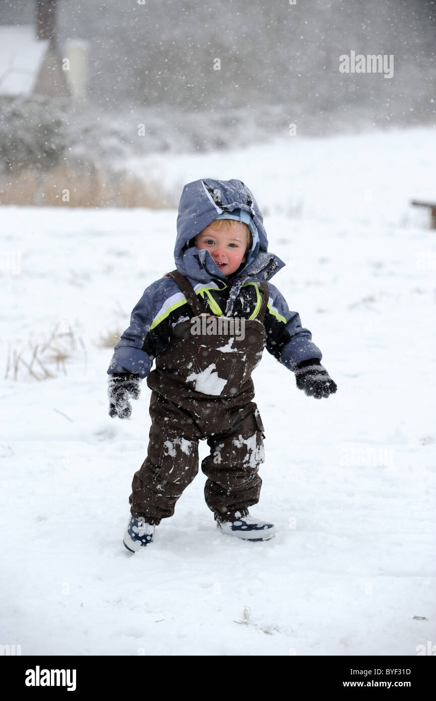 Young child walking in winter snow Stock Photo - Alamy