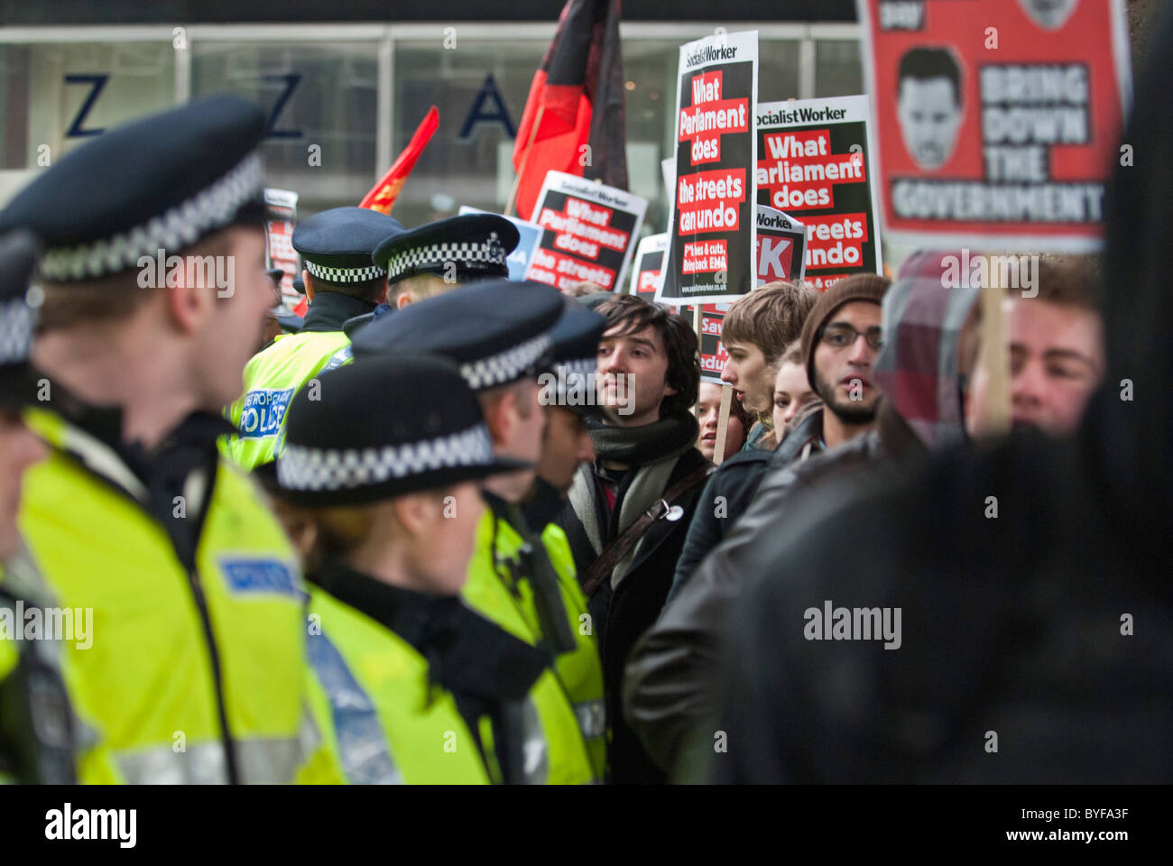 Student protesters confront line of police officers protecting ...