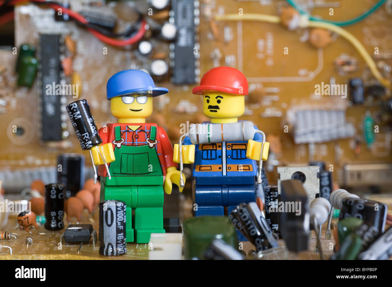 Lego engineers in electronic circuit land holding components ...