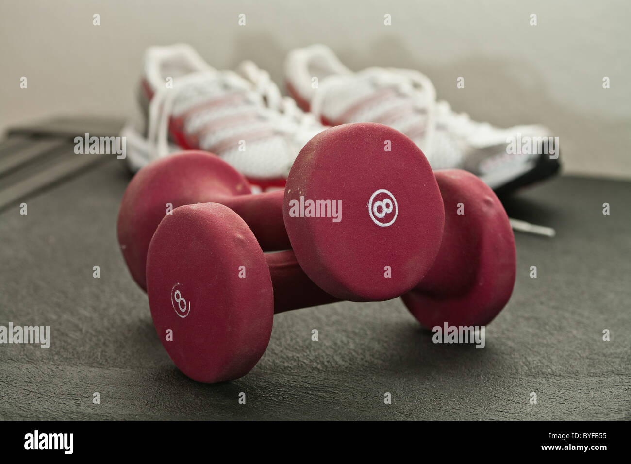 eight pound free weights with a pair of running shoes in the background ...