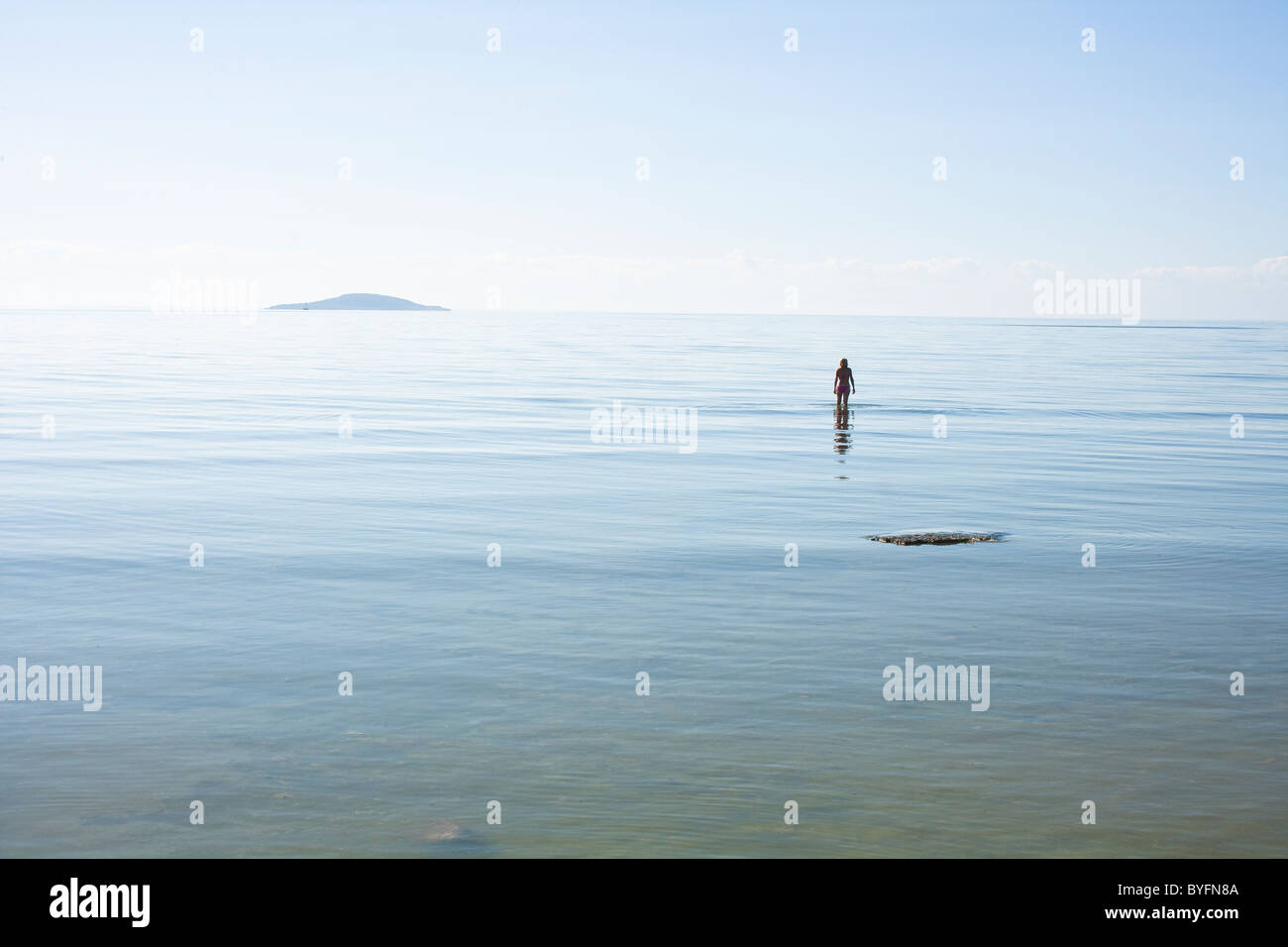 Silhouette of woman wading in sea Stock Photo - Alamy