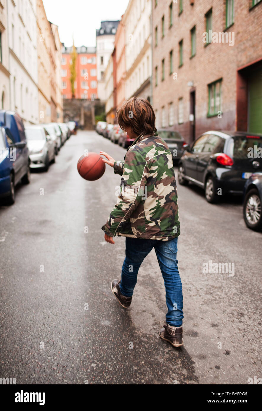 Teenage boy dribbling basketball Stock Photo - Alamy