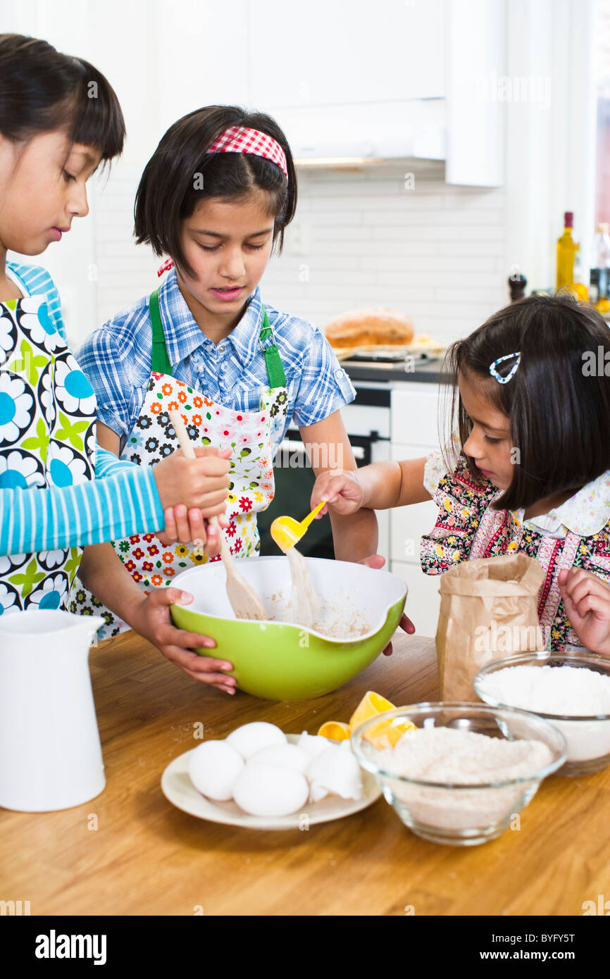 Three girls baking in kitchen Stock Photo - Alamy
