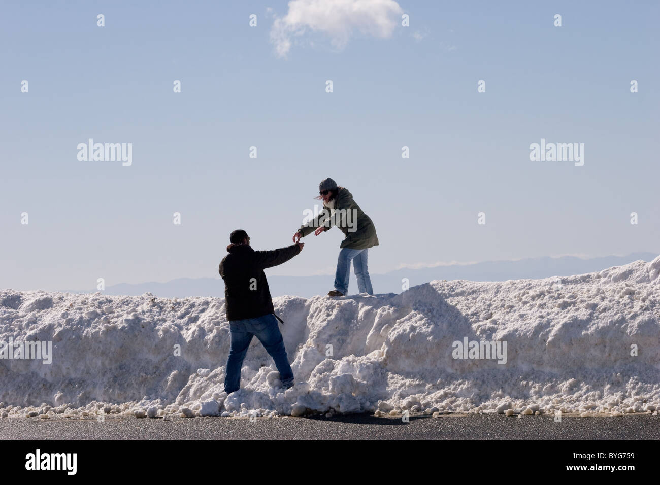 Boy helps his girlfriend to get down Stock Photo - Alamy