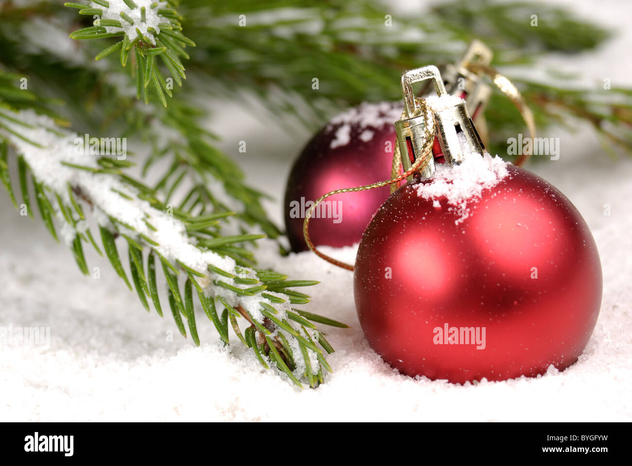 Red christmas balls in the snow near pine branch Stock Photo - Alamy