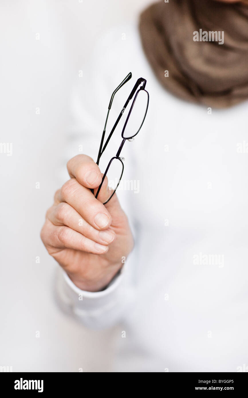 Human hand holding spectacles Stock Photo - Alamy