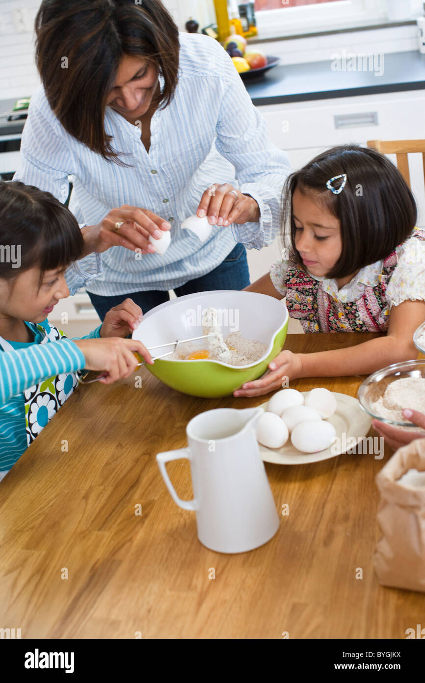 Mother baking with girls in kitchen Stock Photo - Alamy