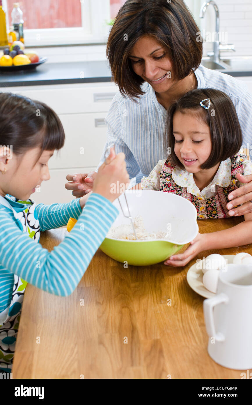 Mother baking with girls in kitchen Stock Photo - Alamy