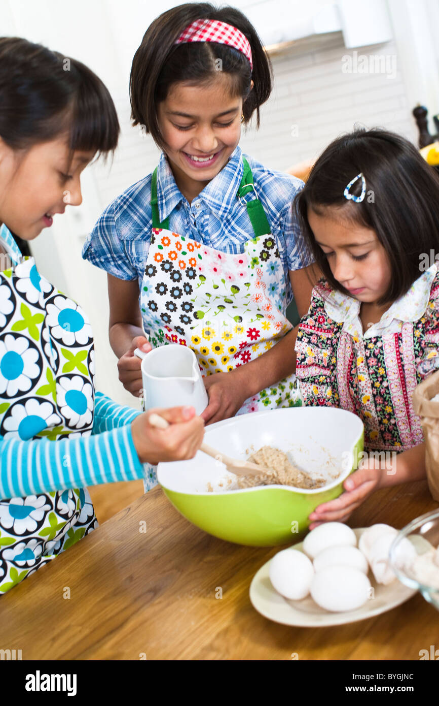 Three girls baking in kitchen Stock Photo - Alamy