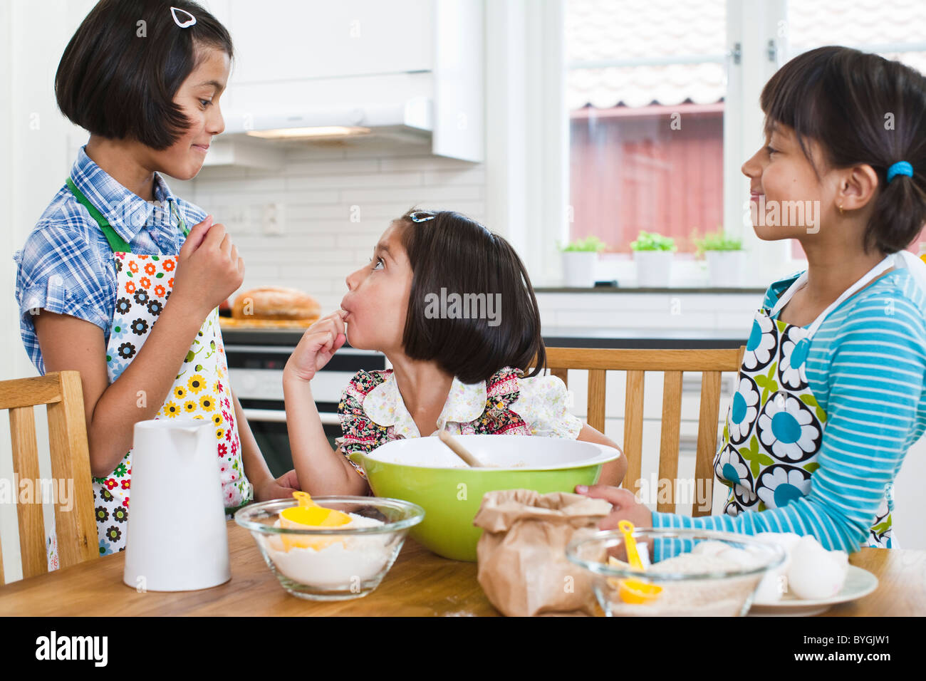 Three girls baking in kitchen Stock Photo - Alamy
