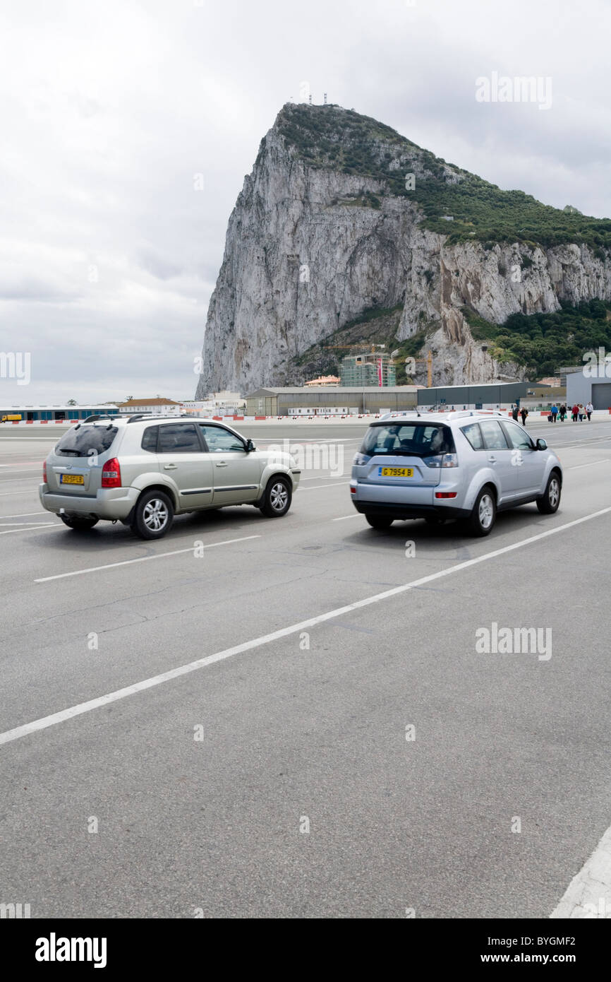 Cars driving on Gibraltar, on airport / air strip / runway road, having ...