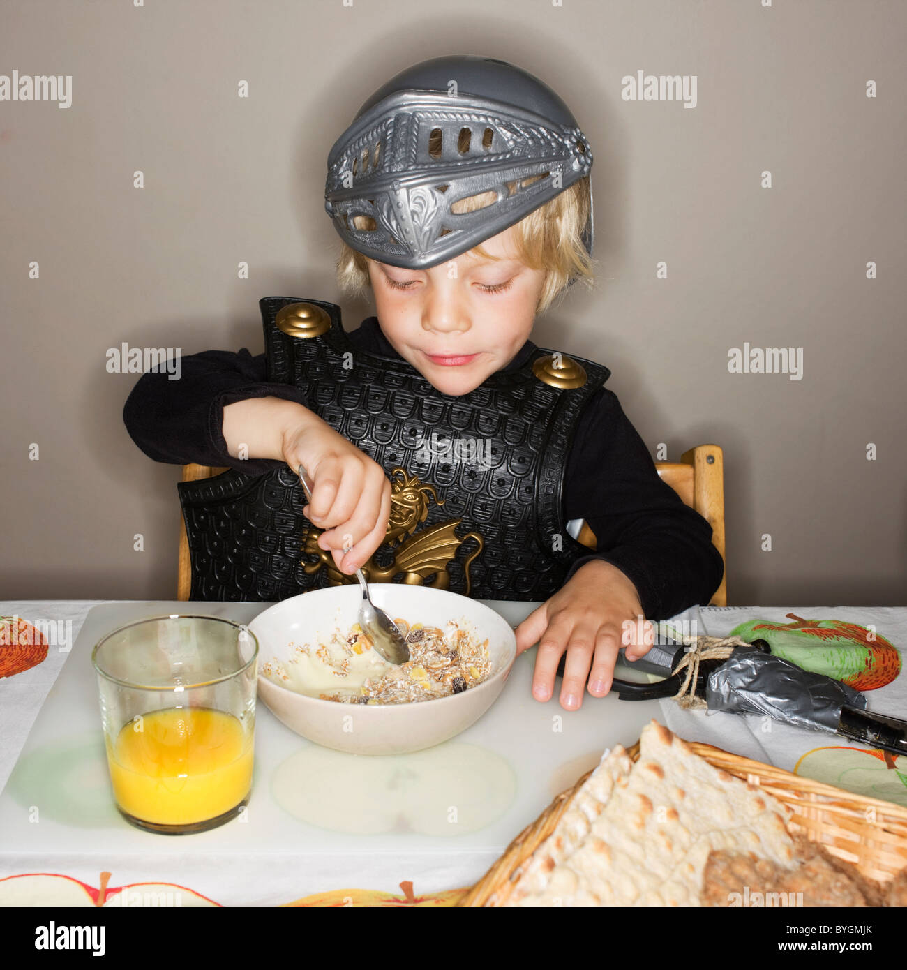 Boy in armour suit eating breakfast Stock Photo - Alamy