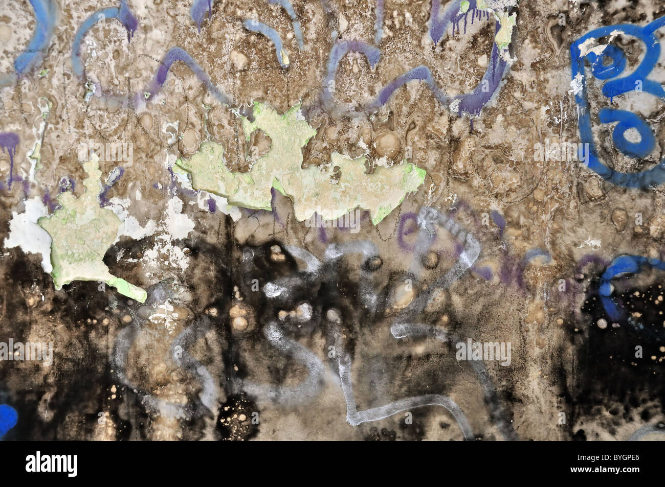 Old peeling grunge wall covered with messy graffiti and mold ...