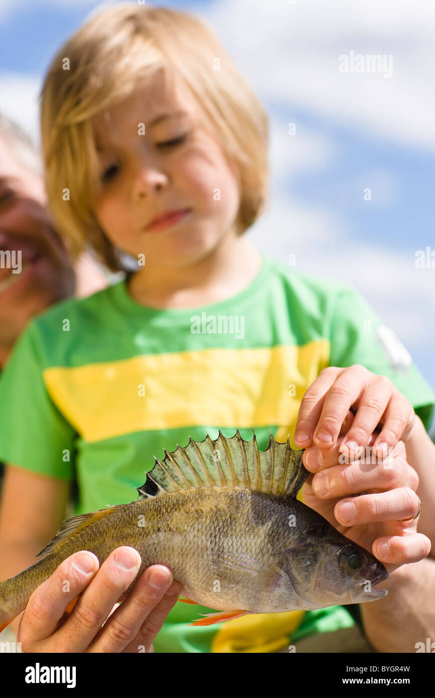 Father and son holding fish, focus on foreground Stock Photo - Alamy