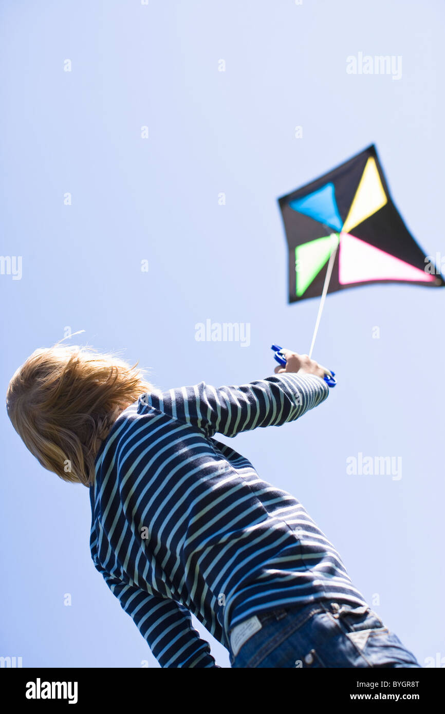 Boy flying kite in bright sunlight, against clear sky Stock Photo - Alamy