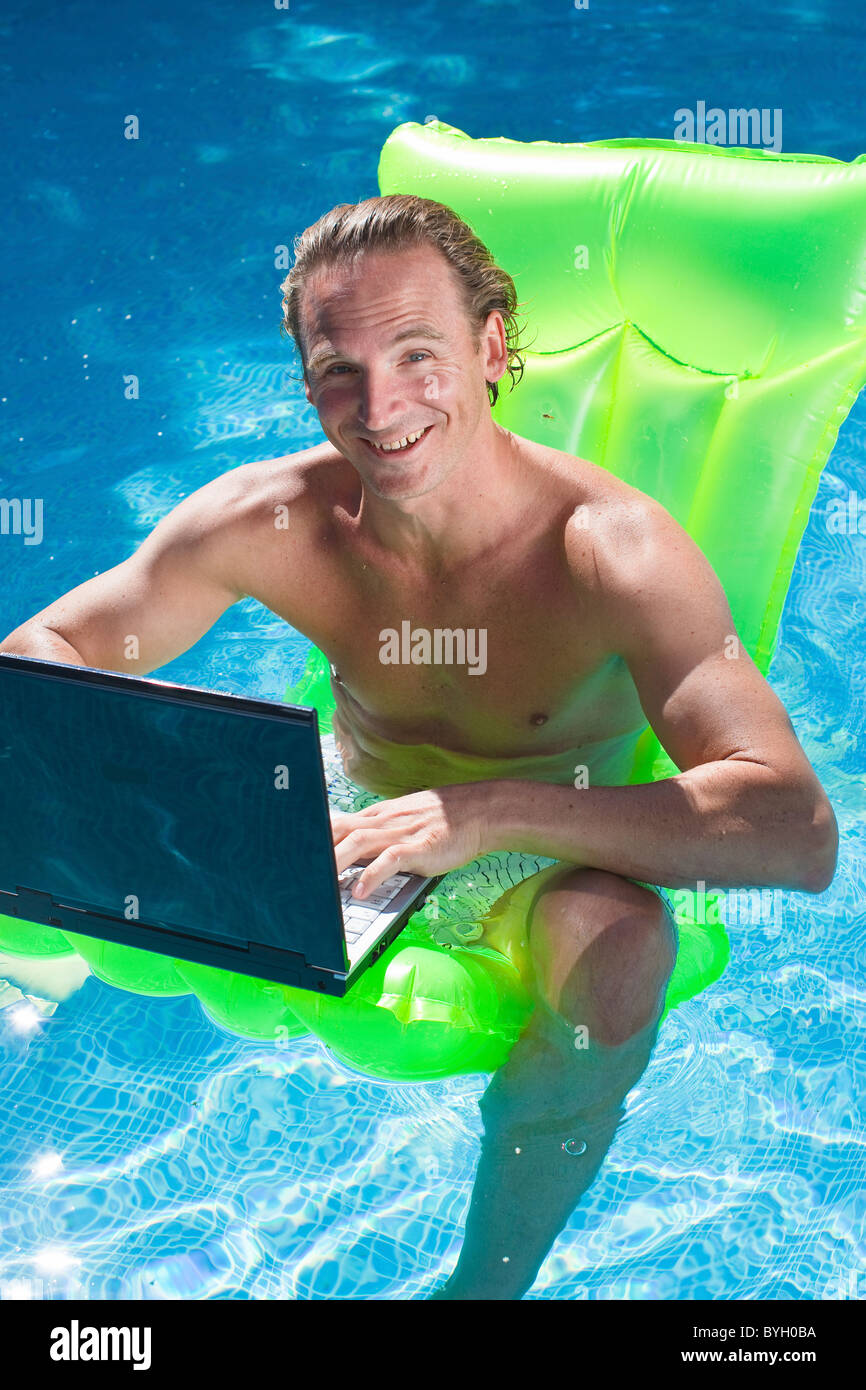 Man sitting on inflatable raft and working on laptop Stock Photo - Alamy