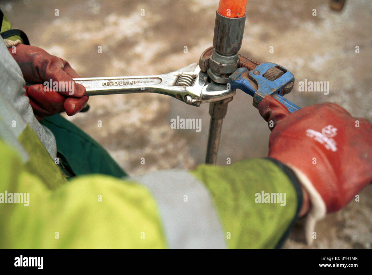 Operative tightening pipe work with wrenches Stock Photo - Alamy
