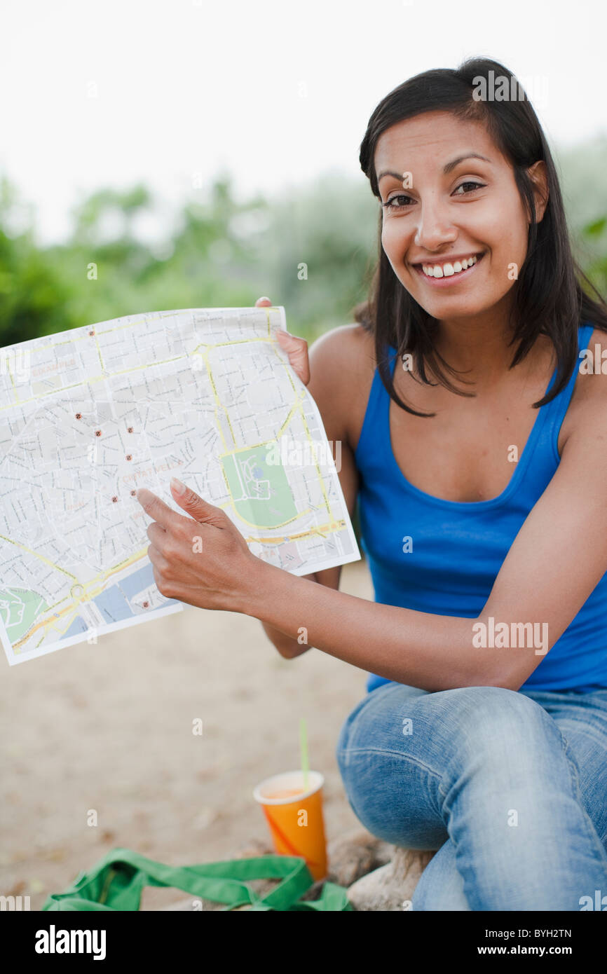 Portrait of woman pointing at map Stock Photo - Alamy