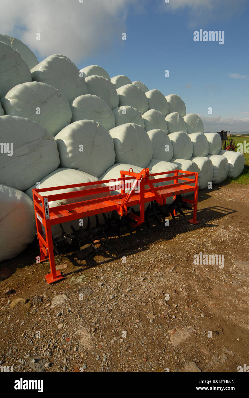 Silage hay bales wrapped in plastic stacked on farmland in ...