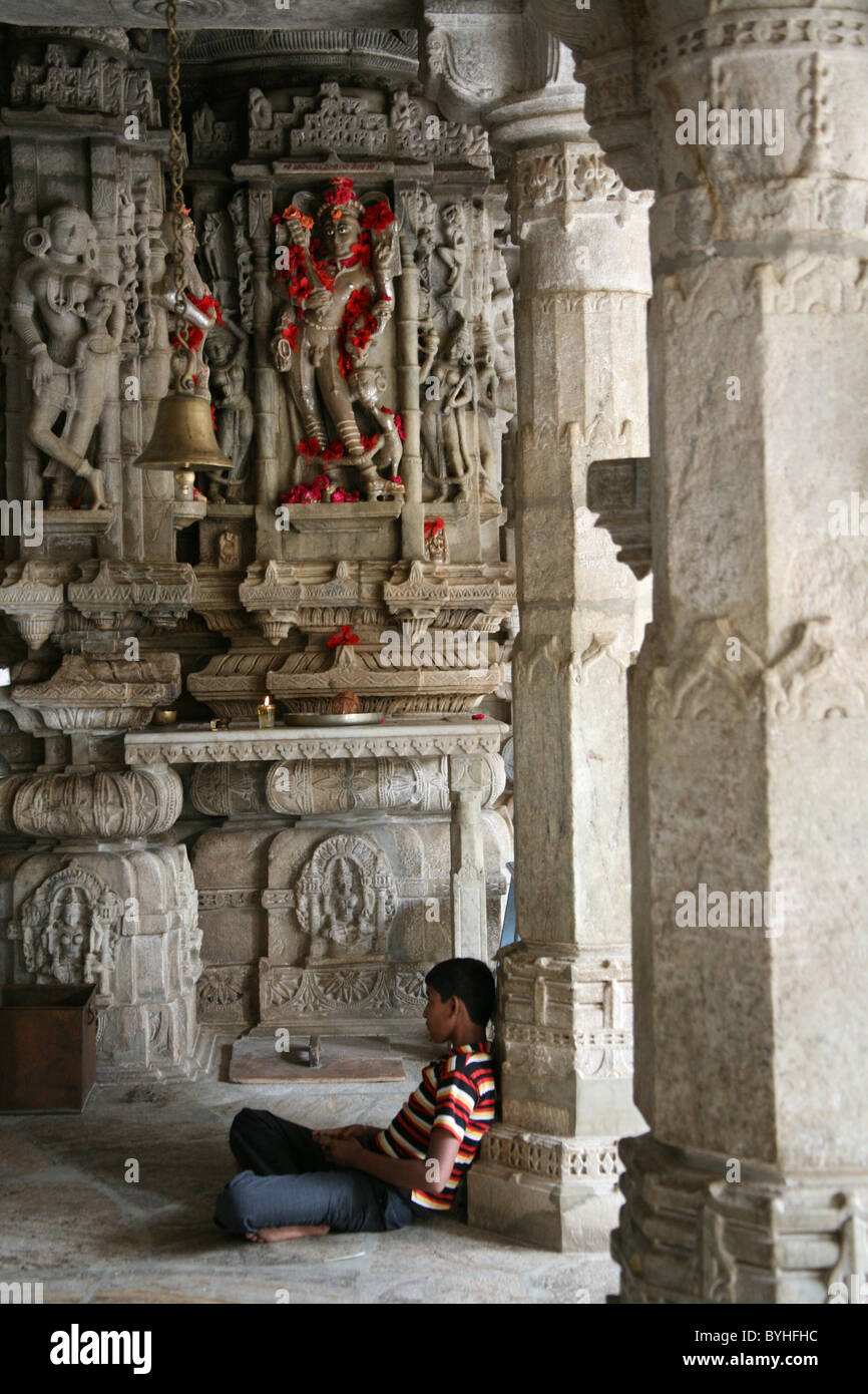 Lone seated worshiper at the marble Jain Adishwar Chaumukha Mandir ...