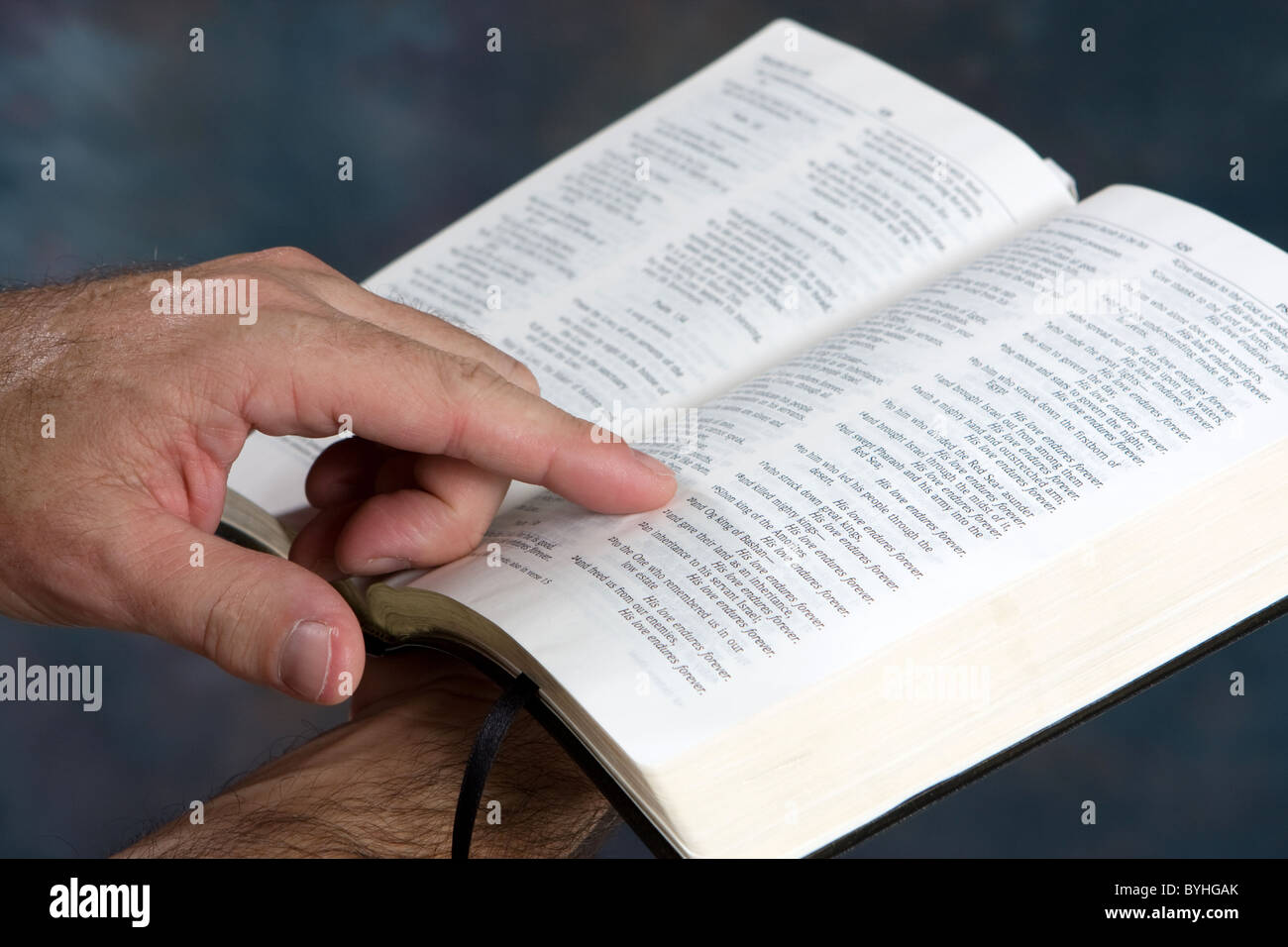 Man holds open bible and reads from scripture Stock Photo - Alamy