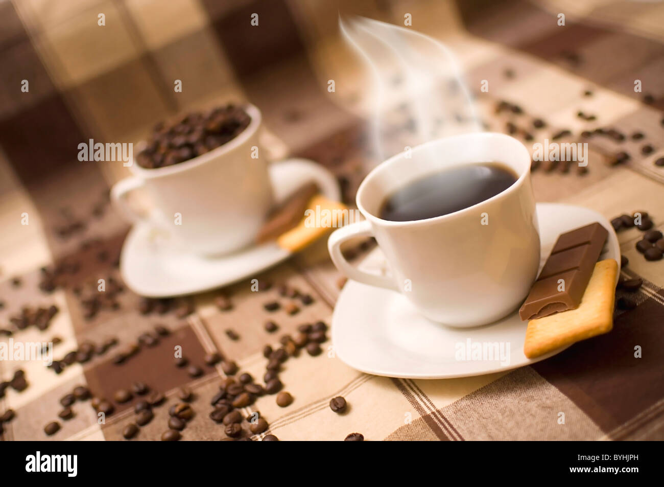 Two cofee cups on table, second one blurred in background Stock Photo ...
