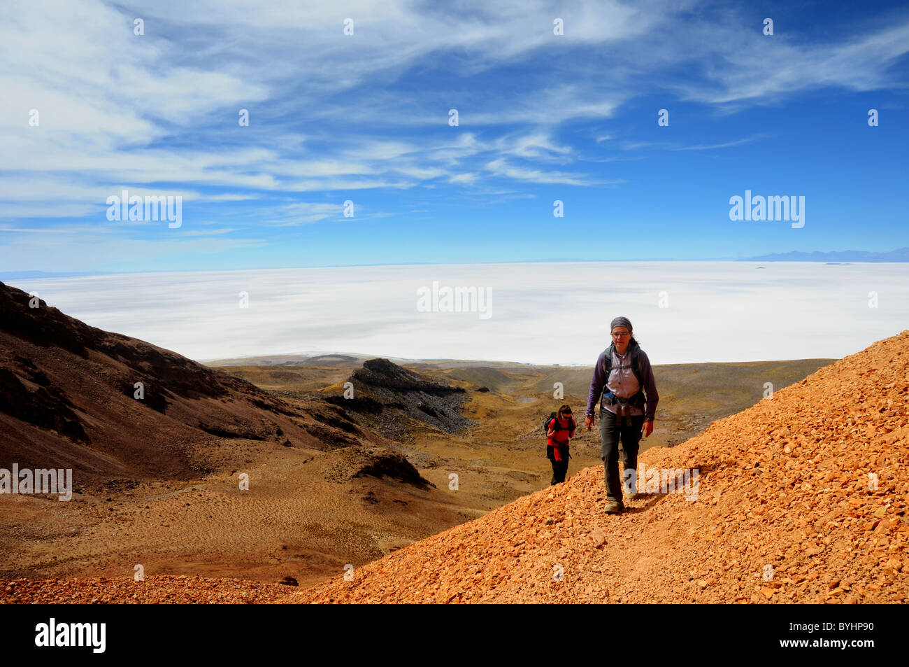 Two trekkers nearing the top of Tunupa volcano in the Salar de Uyuni in ...