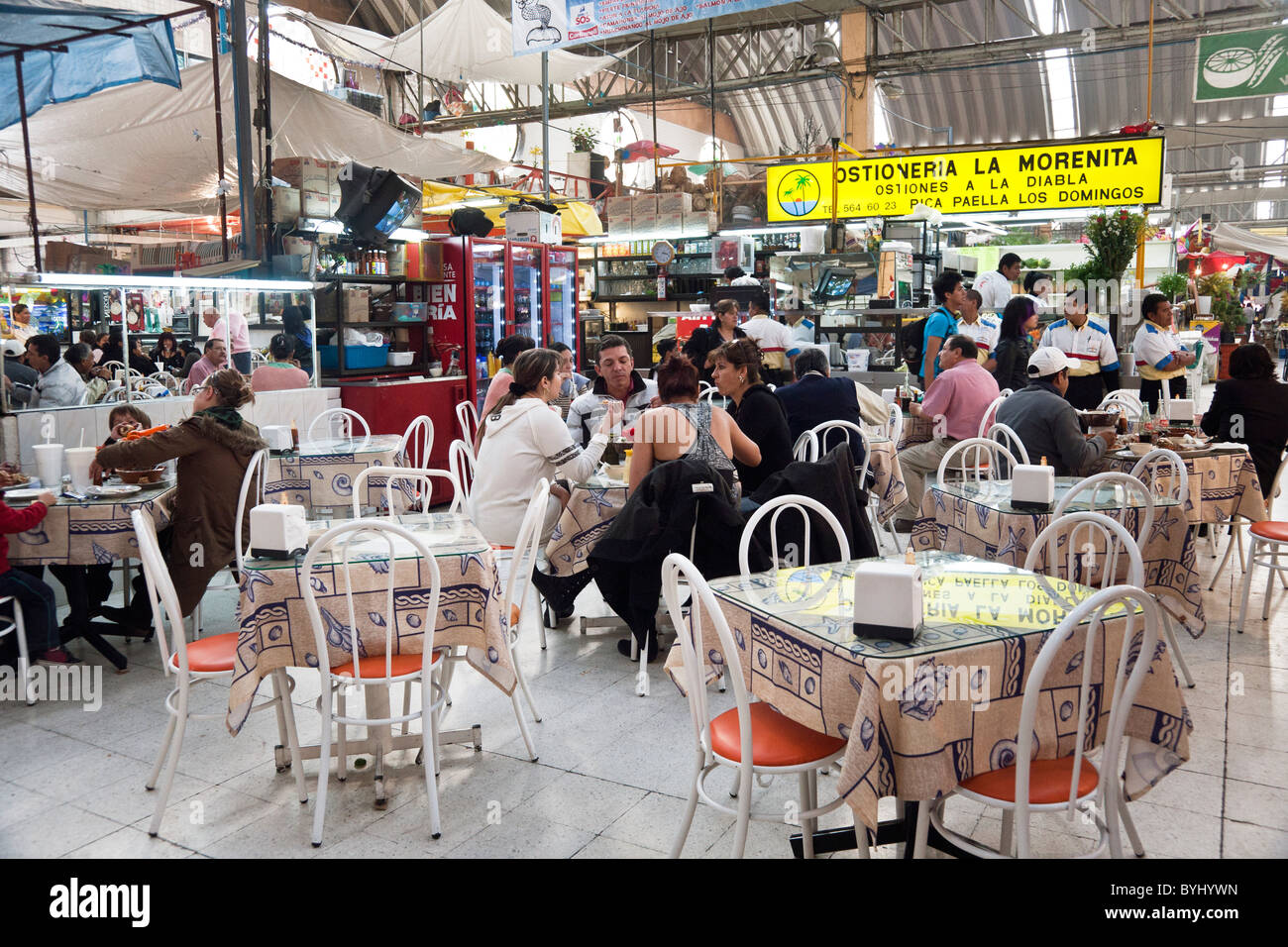 people crowd restaurant seating area in Medellin market to enjoy hearty ...