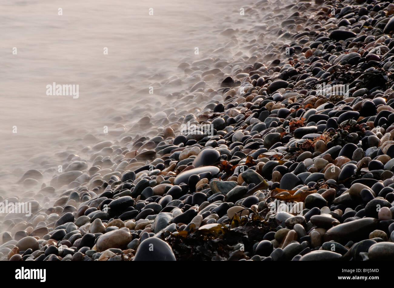 Pebbles and hazy waves, Cemlyn Bay Stock Photo - Alamy