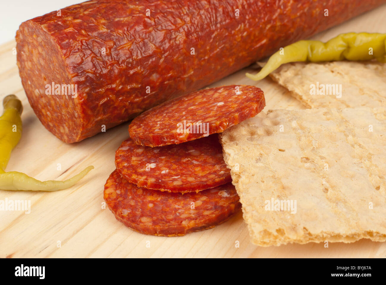 Delicious freshly sliced salami with bred and hot peppers Stock Photo ...