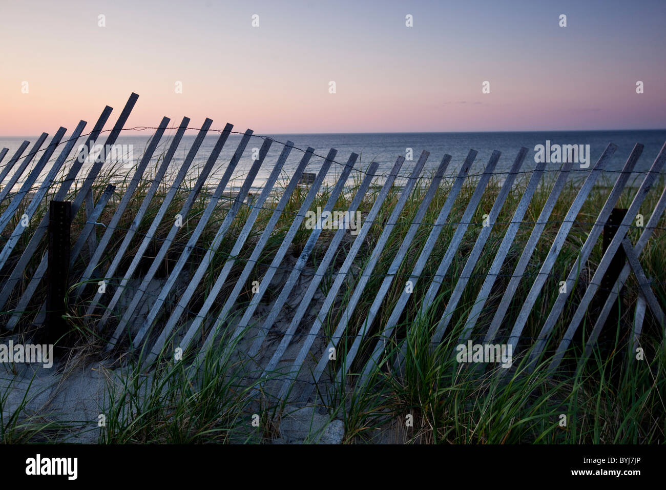 USA, Massachusetts, Barnstable, Fence along Cape Cod sand dunes at ...