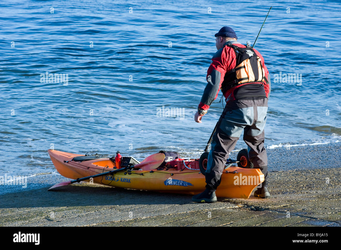 Man in a sea kayak with a fishing rod attached. Sandsend, Whitby, UK ...
